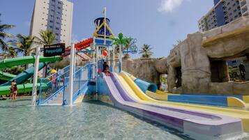 Um parque aquático com vários toboáguas e uma placa indicando que faz parte do Parque GAV.