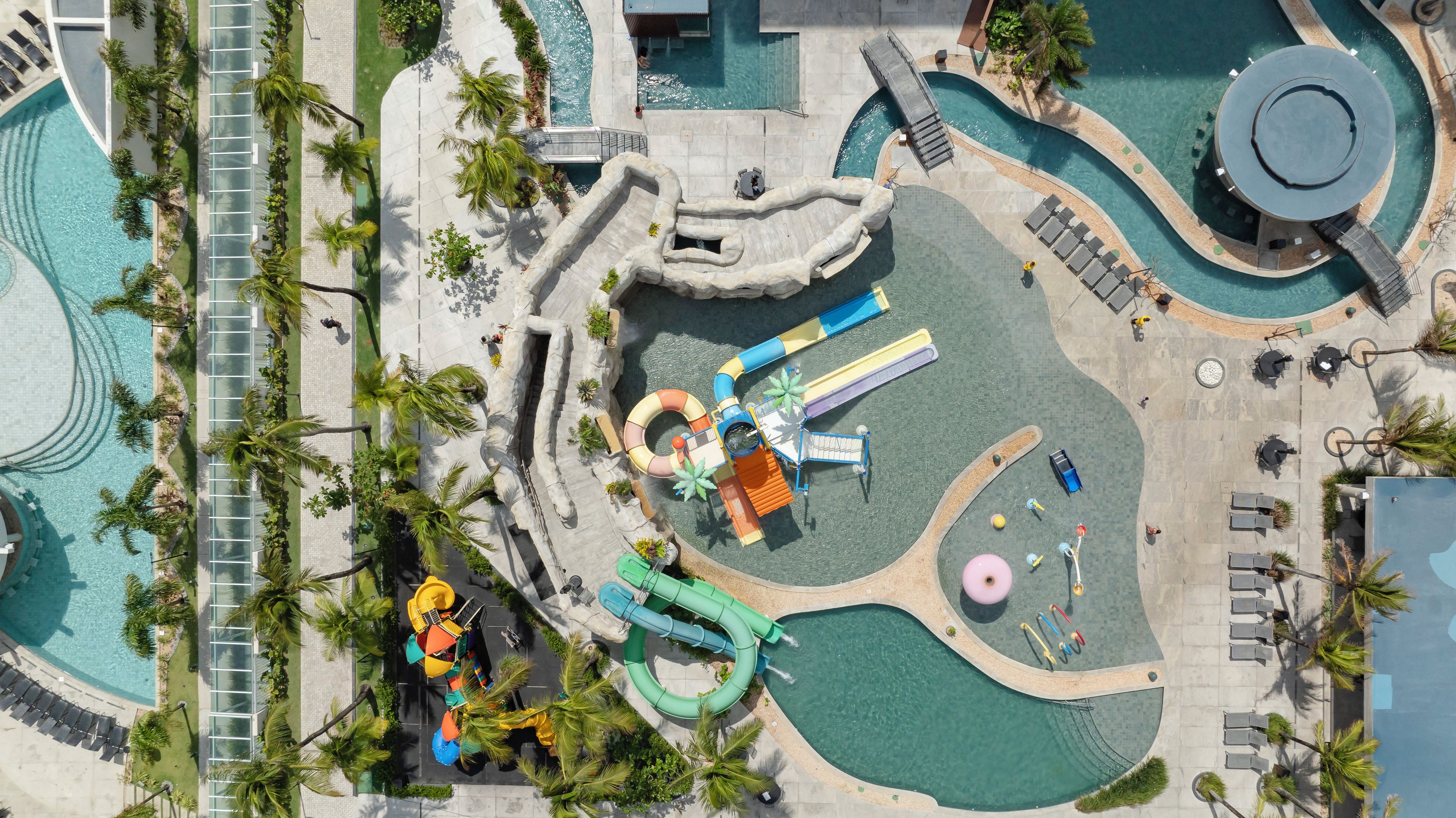 Vista aérea de um resort com várias piscinas, toboáguas e áreas de lazer.