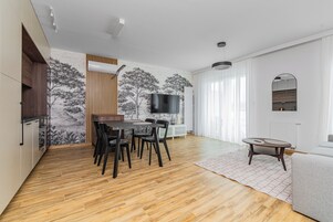 Um espaço de estar moderno com área de refeições, TV de tela plana e um canto de estar aconchegante.