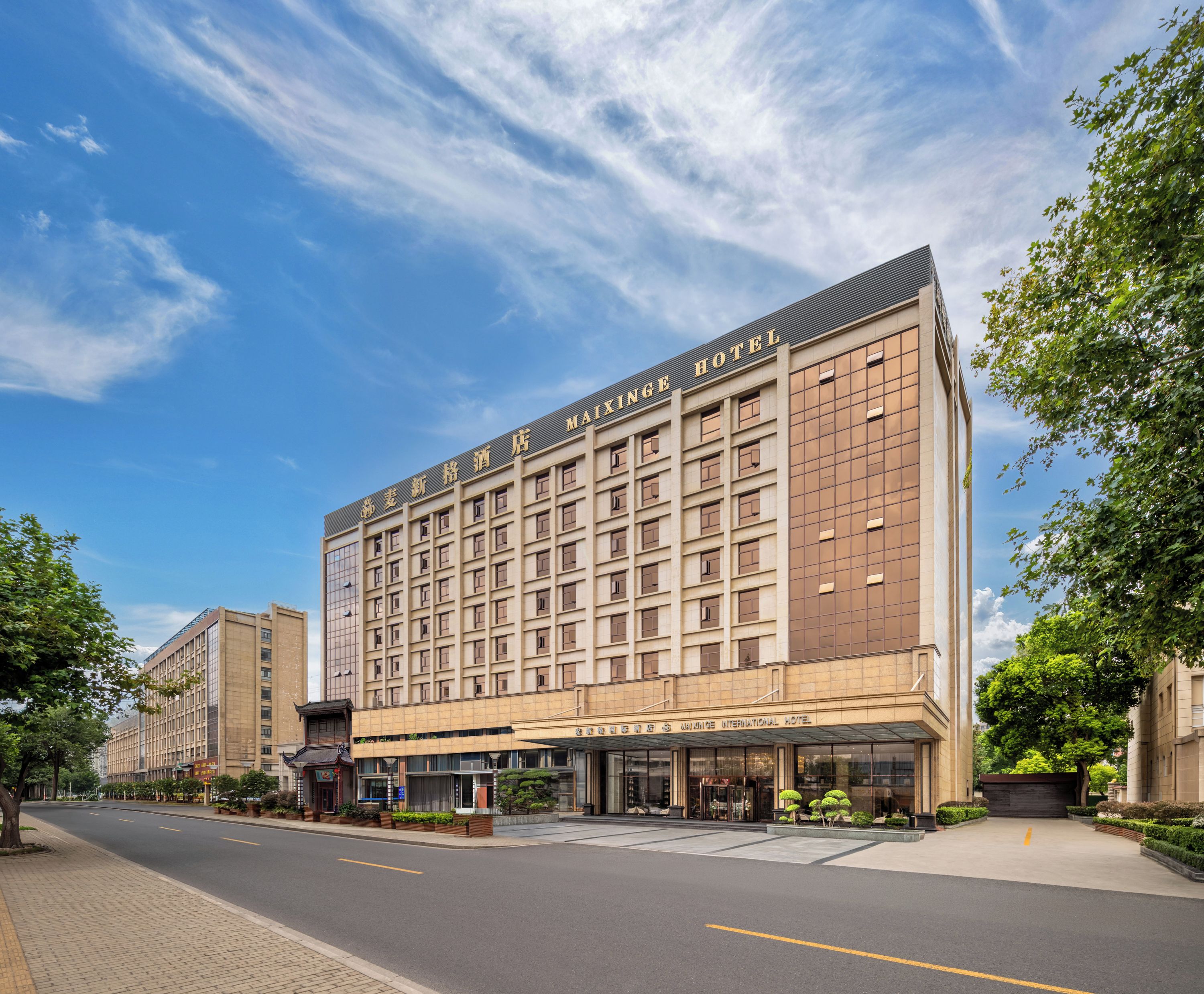 Um hotel de vários andares com fachada moderna, janelas amplas e céu claro.