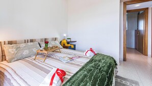 Quarto bem arrumado com cama, mesa de cabeceira e luminária.