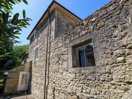 Um edifício de pedra com uma janela e uma porta.