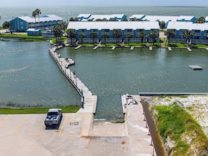 Hotel à beira-mar com um cais, área de estacionamento e vista para o oceano.