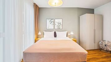 Quarto de hotel moderno com uma cama grande, abajures, uma luminária de teto e um guarda-roupa.