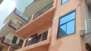 Um edifício de vários andares com varandas, janelas e uma porta.