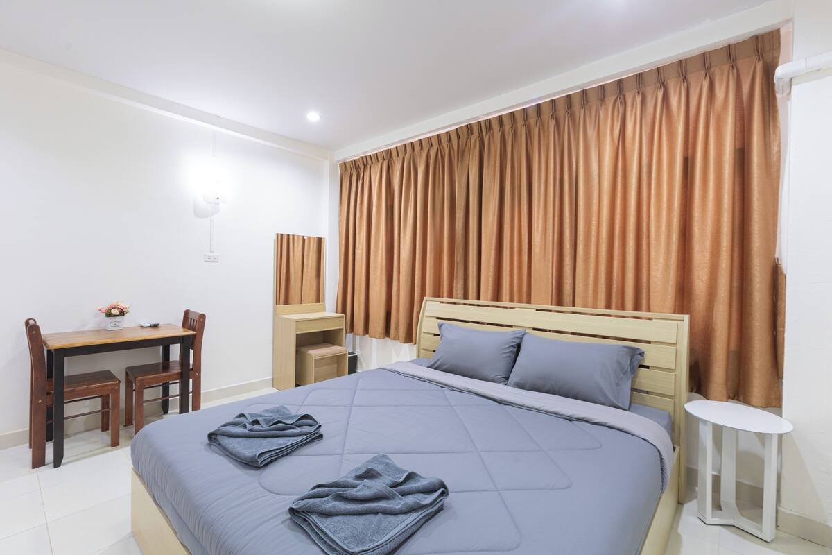 Quarto com cama, escrivaninha e cadeira.