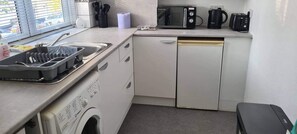 Um frigorífico, um micro-ondas, um forno, uma placa de cozinha