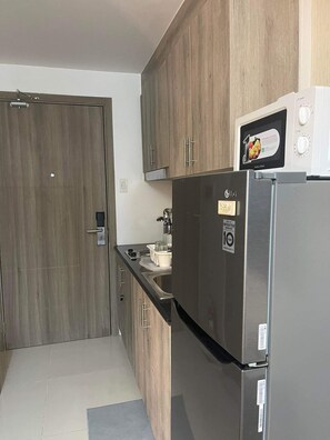 Apartamento Básico em Condomínio Fechado, 1 quarto, varanda, vista para a piscina | Cozinha privada | Um frigorífico/congelador grande, um micro-ondas, uma placa de cozinha 