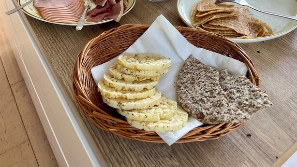 Um buffet de café da manhã com diversos alimentos e acompanhamentos.