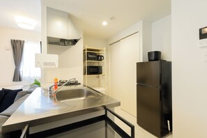 Um frigorífico, um micro-ondas, uma placa de cozinha, uma torradeira 