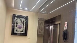 Um elevador moderno com painel de comando e telefone fixado na parede.