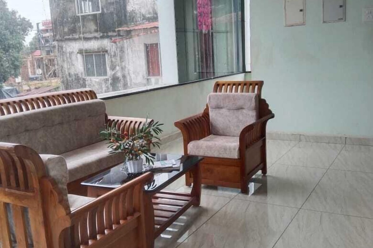 Varanda espaçosa com sofá, poltronas e mesa de centro.