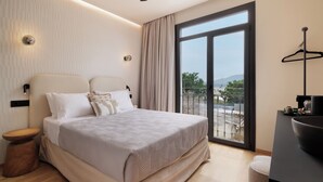 Quarto moderno com uma cama grande, mesa de cabeceira, luminária pendente e vista para o exterior.