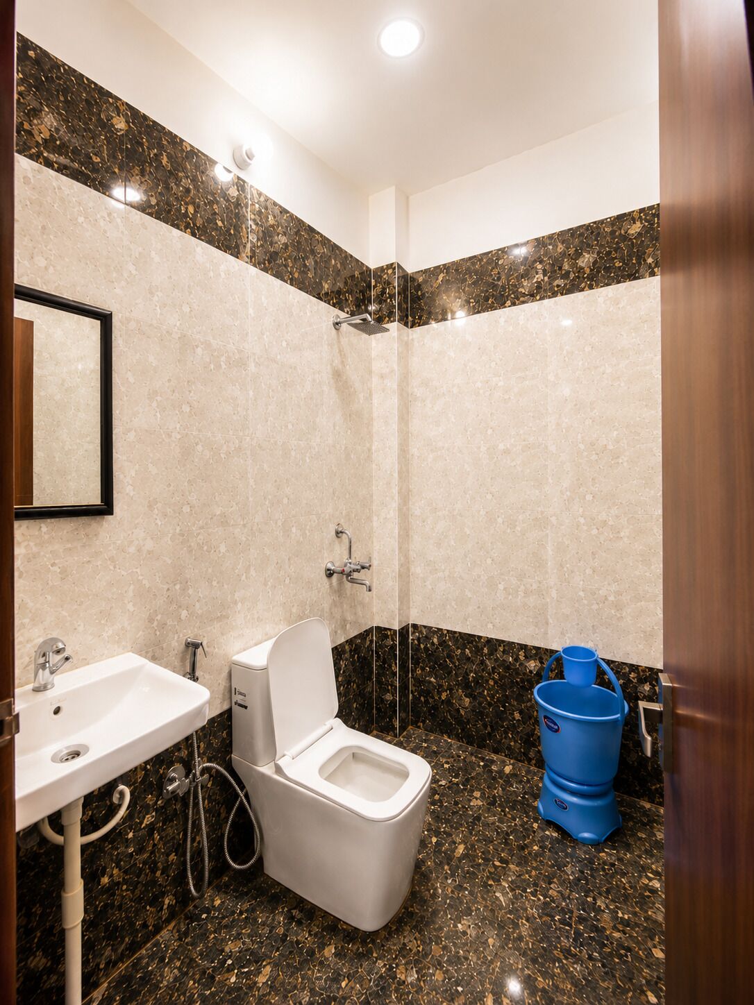 Casa de banho com sanita, lavatório e chuveiro.