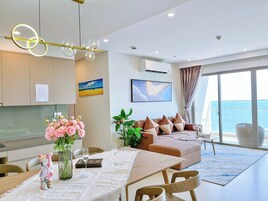 Apartamento luxo, 3 quartos, vista para o oceano | Área de estar | TV de tela plana 55 polegadas com canais a cabo