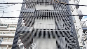 Um edifício alto com uma placa que diz "KOUZU".