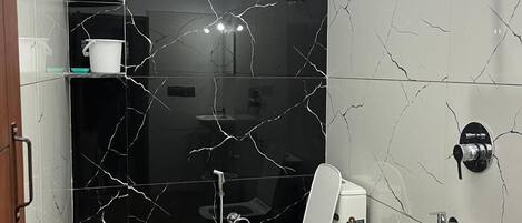 Casa de banho com sanita, chuveiro e lavatório.