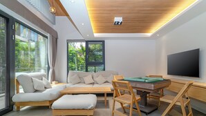 Uma sala de estar moderna com sofá, banqueta, mesa de jantar e cadeiras.