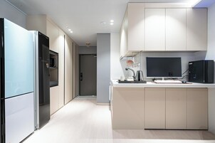 Uma cozinha moderna com frigorífico, micro-ondas e forno embutido.