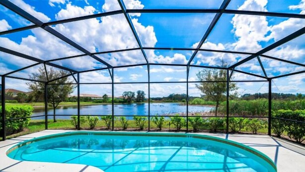 Piscina coberta com vista para um lago e vegetação ao redor.
