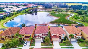 Zona residencial com casas, um lago e céu claro.