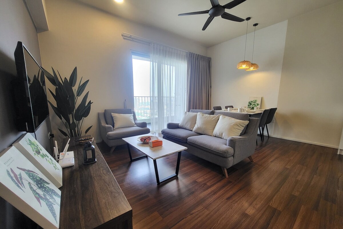 Uma sala moderna com sofá, poltronas, mesa de centro e um espaço de jantar com mesa e cadeiras.