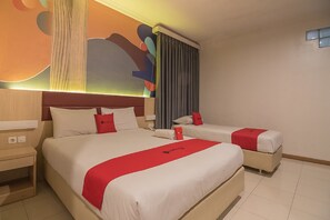 Quarto de hotel com duas camas, um quadro abstrato grande na parede e uma cortina.