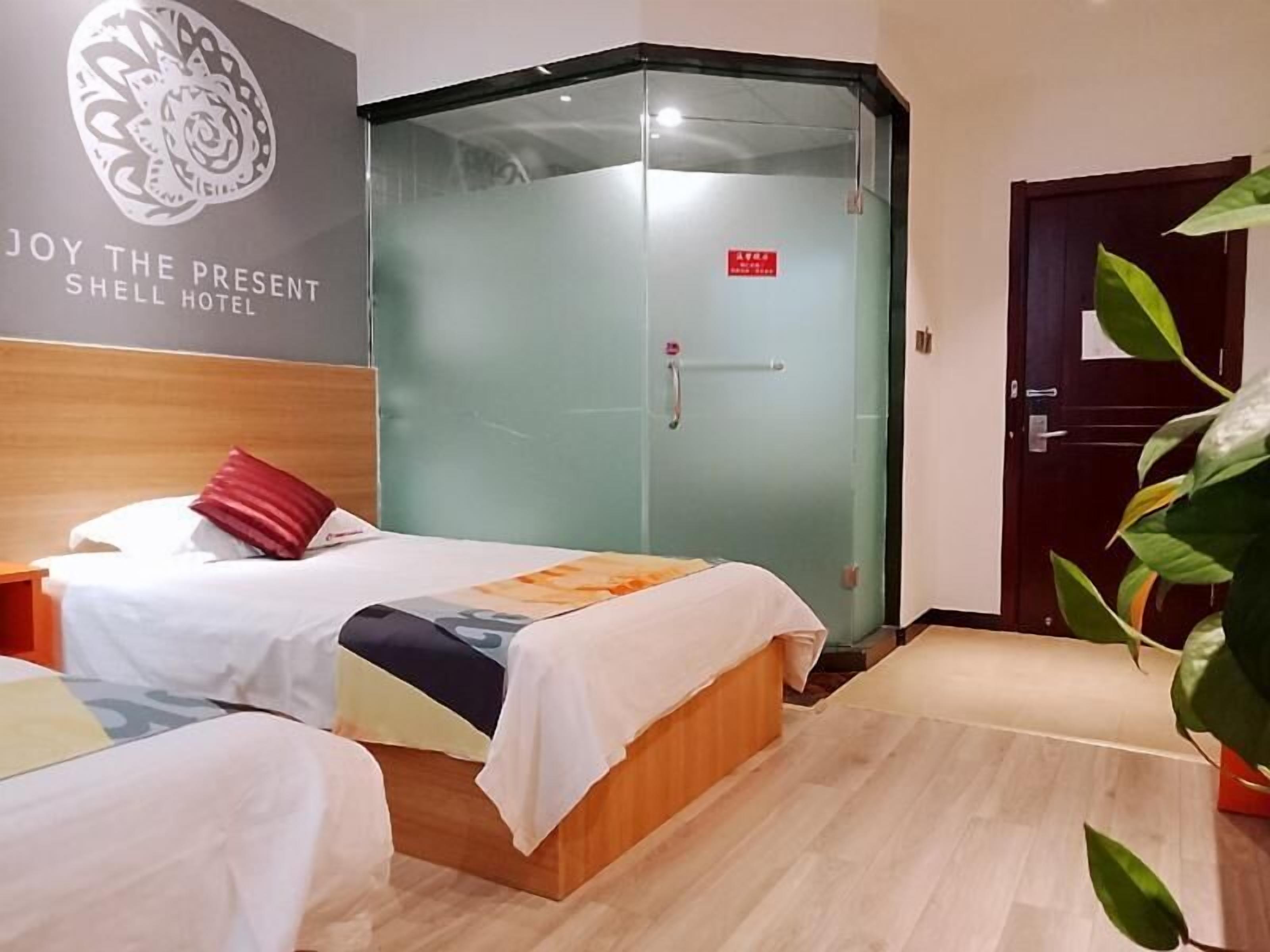 Quarto de hotel com uma cama, um guarda-roupa e uma planta.