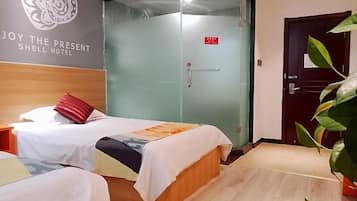 Quarto de hotel com uma cama, um guarda-roupa e uma planta.