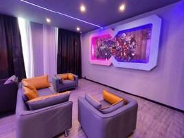 Sala de estar moderna com dois sofás e uma mesa de centro, um quadro abstrato grande na parede, e uma janela com cortinas.