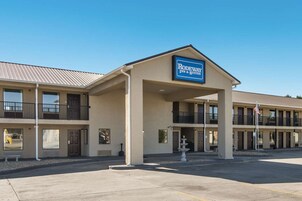 Um motel com uma placa que diz 'Rodeway Inn & Suites'. Possui uma estrutura de dois andares com varandas e entrada coberta.