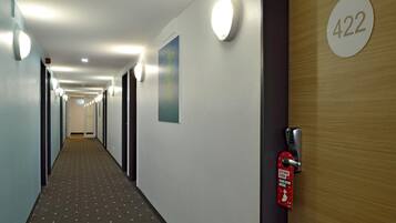 Corredor de hotel com placa de número 422, alarme de incêndio e porta com fechadura eletrônica.