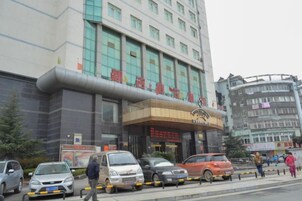 Um hotel com fachada moderna, vários andares e entrada destacada.