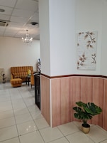Uma área de recepção com um balcão de madeira, um sofá e um candelabro.