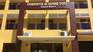 Um edifício com uma placa que diz 'CHERRYS @ HOME TOO Inland Resort'.