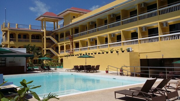 Um hotel com área de piscina, espaço para sentar ao ar livre e várias varandas.