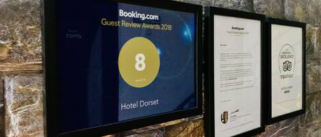 Exposição emoldurada dos Prémios de Avaliação Guest da Booking.com de 2018 para o Hotel Dorset, destacando uma classificação de 8 em 10.