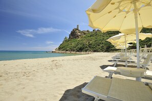 Uma praia privada, espreguiçadeiras, guarda-sóis de praia