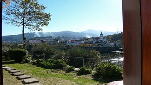 Vista de uma cidade com uma igreja imponente, uma ponte e um rio.