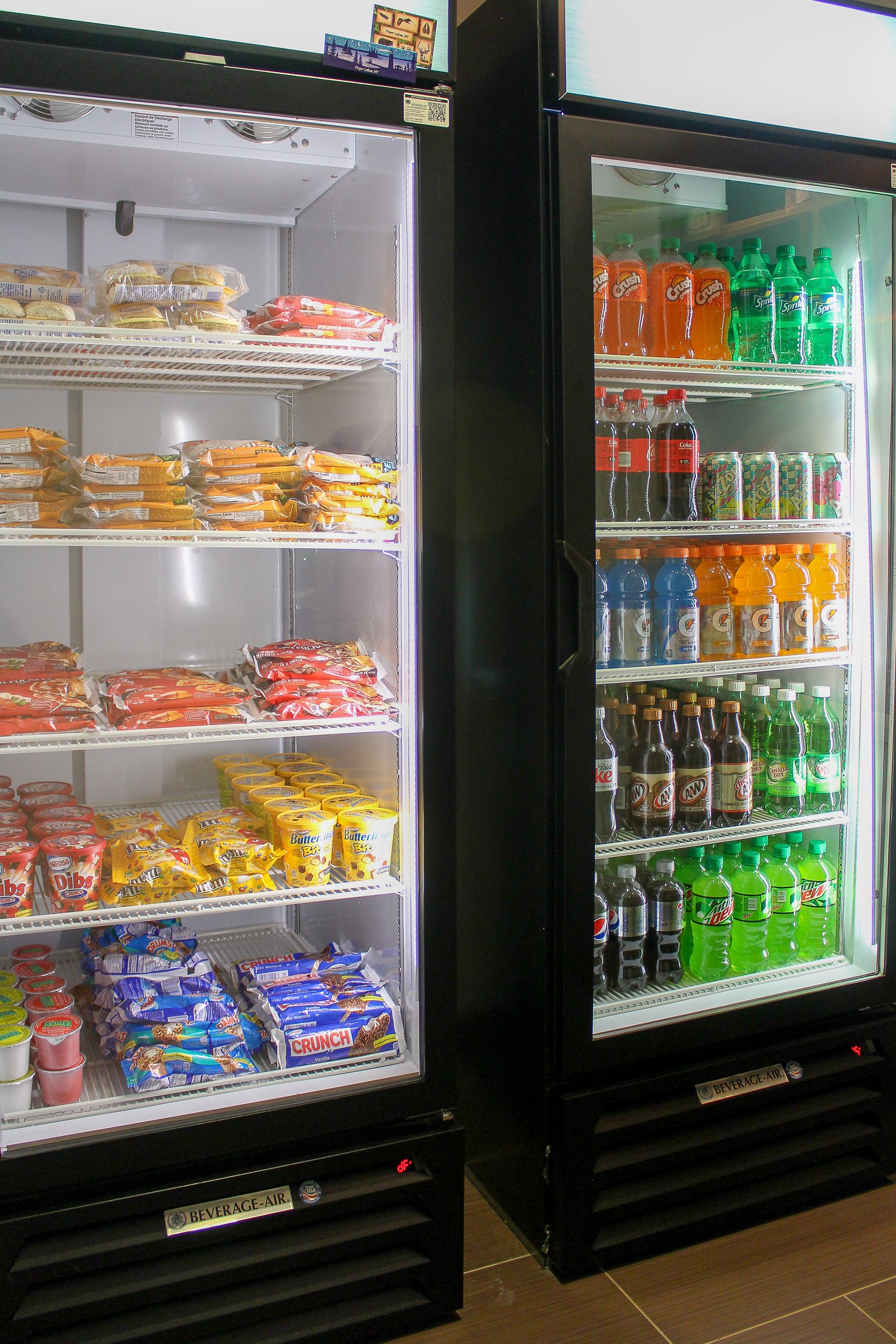 Duas máquinas de venda automática repletas de bebidas e lanches.