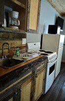 Um frigorífico, uma placa de cozinha, uma cafeteira/bule 