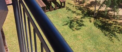 Uma área gramada com uma mesa para piquenique e uma cerca.
