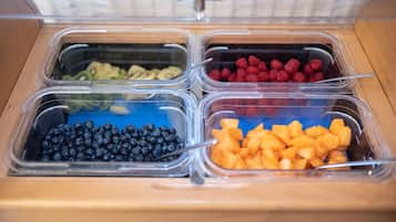 Recipiente de armazenamento de alimentos com quatro compartimentos contendo bananas fatiadas, mirtilos, framboesas e melancia picada.