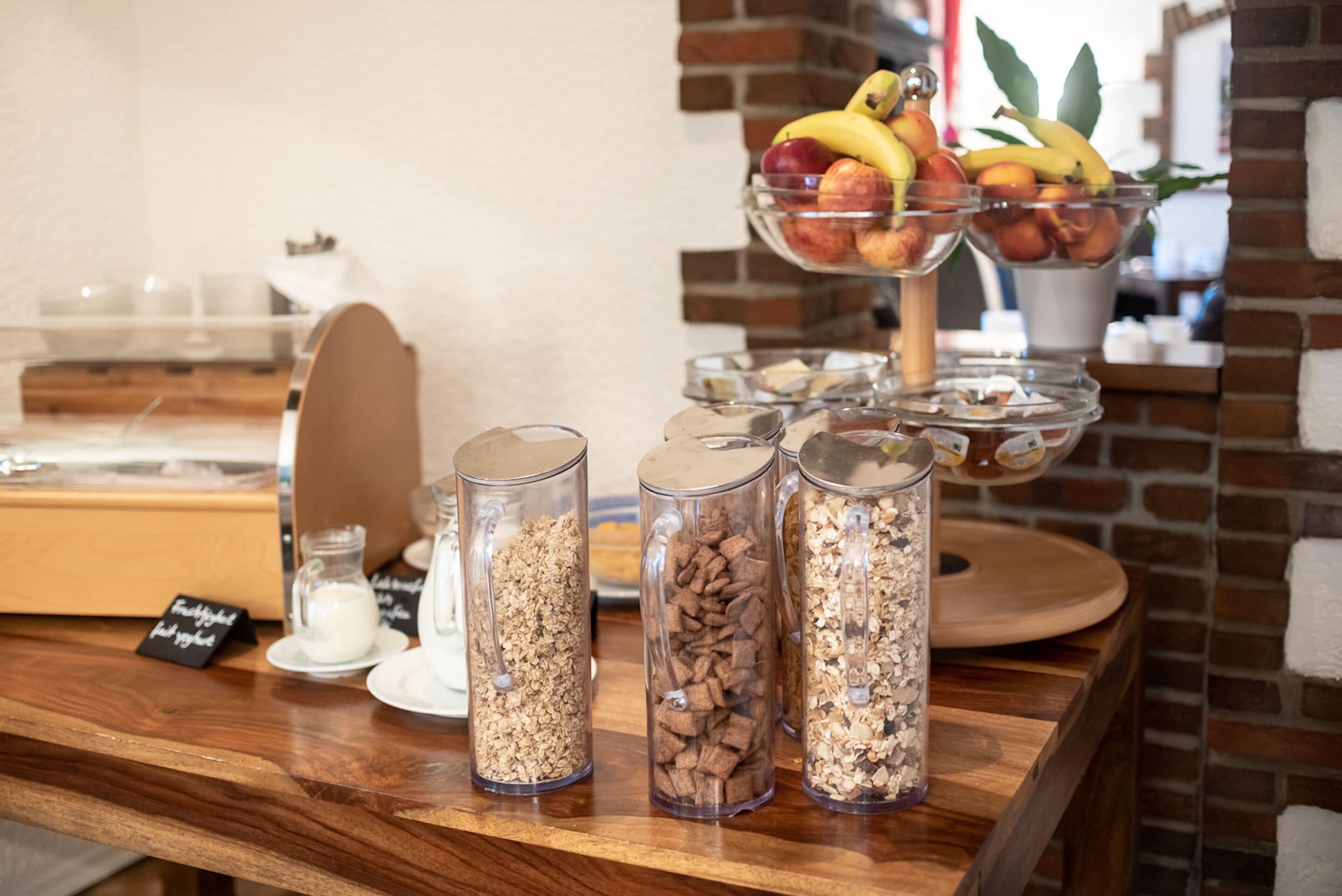 Um buffet de café da manhã com diversos alimentos e recipientes.