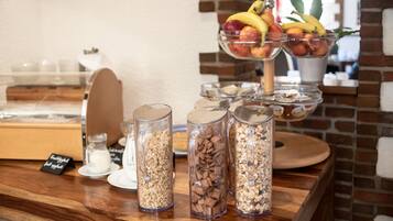 Um buffet de café da manhã com diversos alimentos e recipientes.