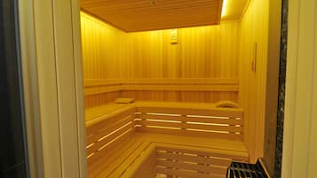 Sala de sauna com bancos de madeira e um banco com toalha.