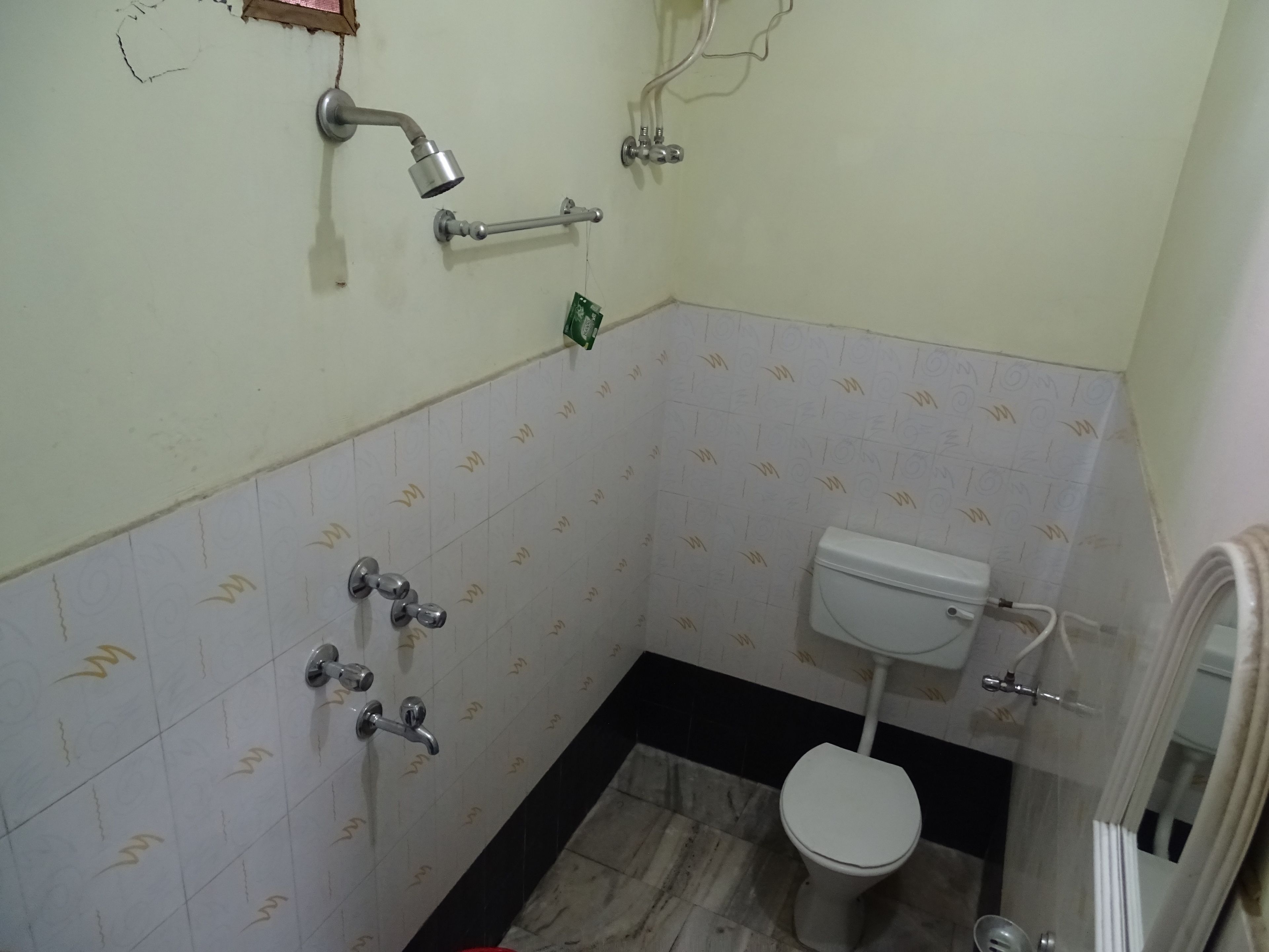 Uma casa de banho pequena com sanita, chuveiro e lavatório.