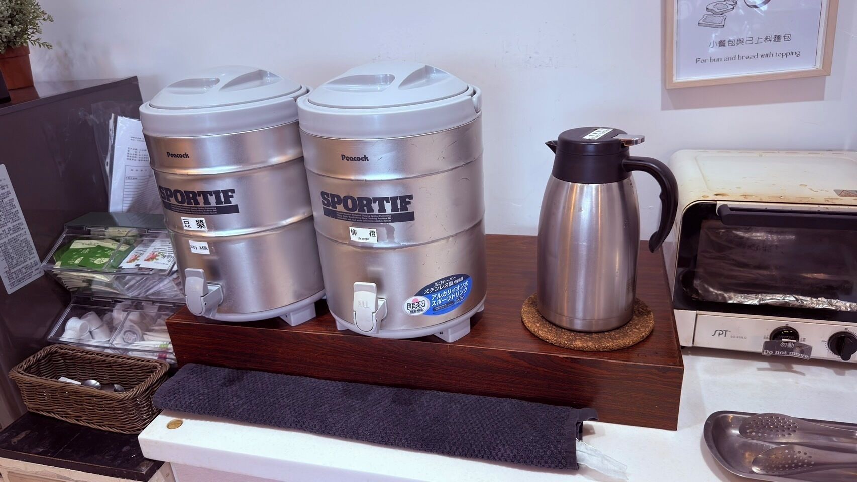 Dois recipientes de aço inoxidável com a etiqueta 'SPORTIF' em uma bancada com uma cafeteira e uma torradeira.