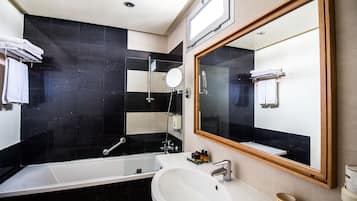 Uma casa de banho moderna com banheira, pia e um espelho grande.