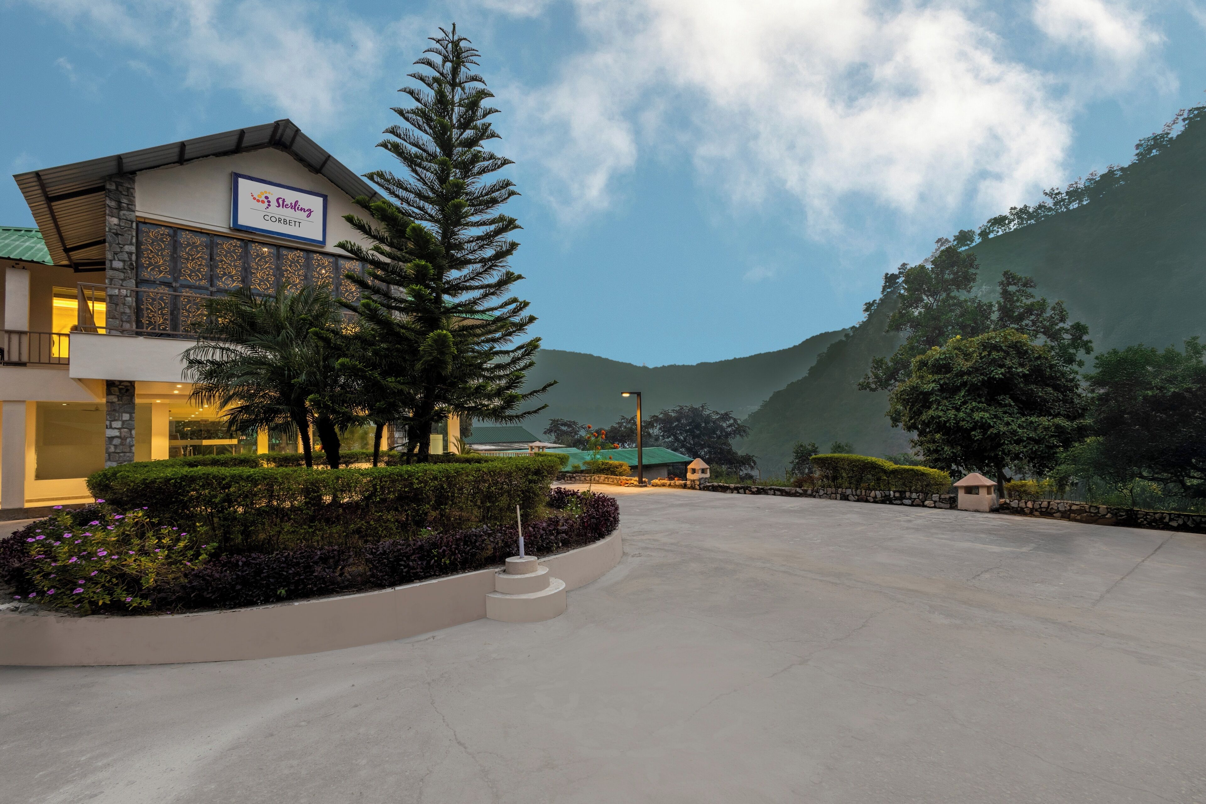 Um hotel chamado 'Sleking Corbett' com design arquitetônico moderno, área de jardim ajardinada e um cenário montanhoso.